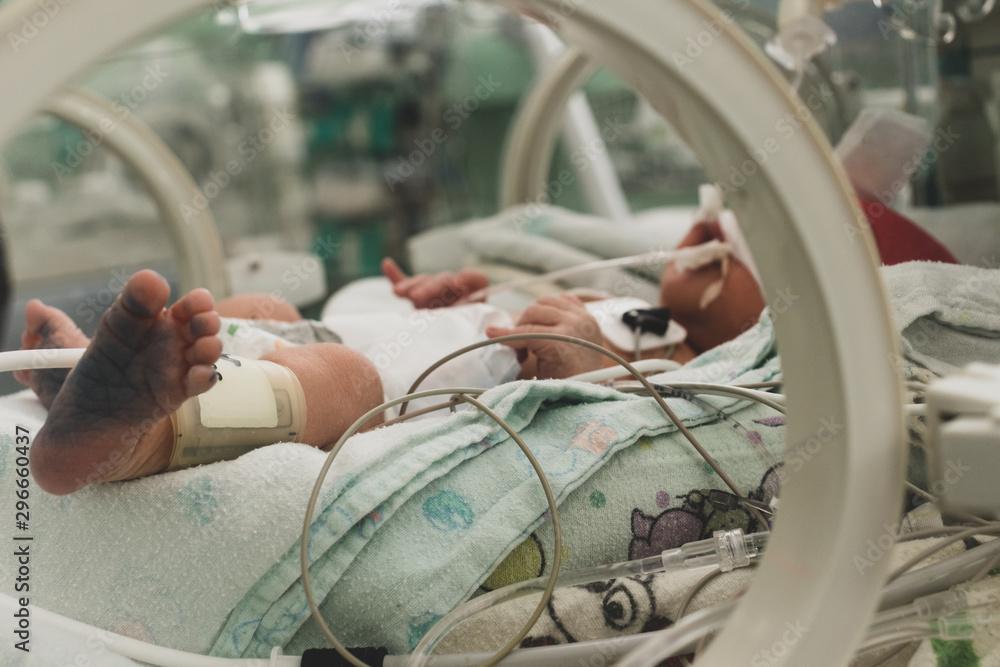 Incubator with a sick newborn baby at neonatal intensive care unit ...