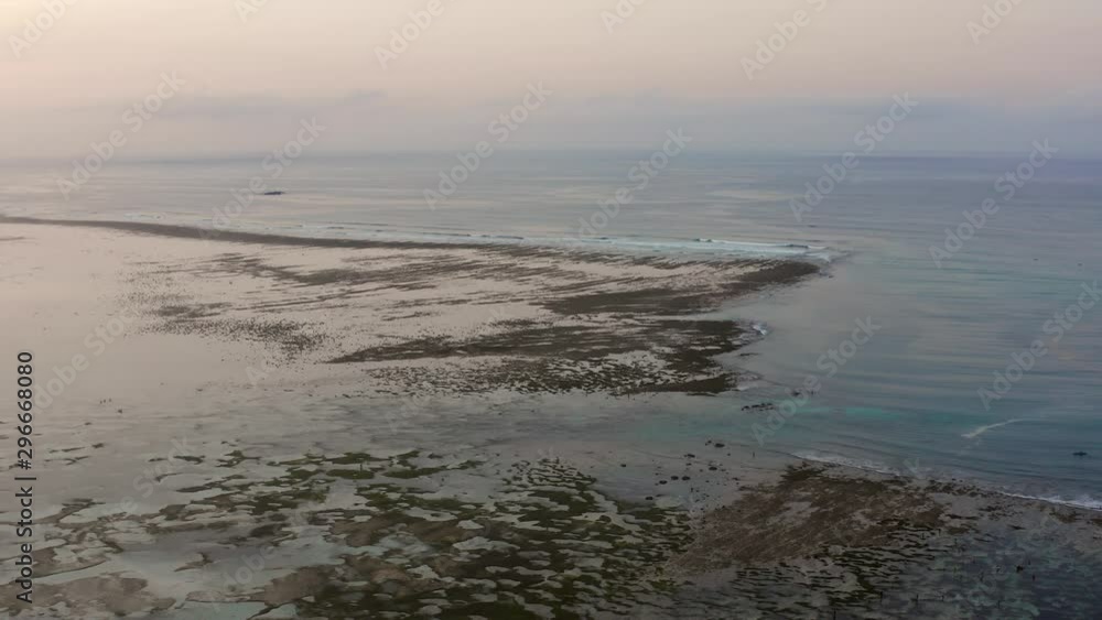 The dry reef of Kuta Lombok during sunrise, with local people looking ...
