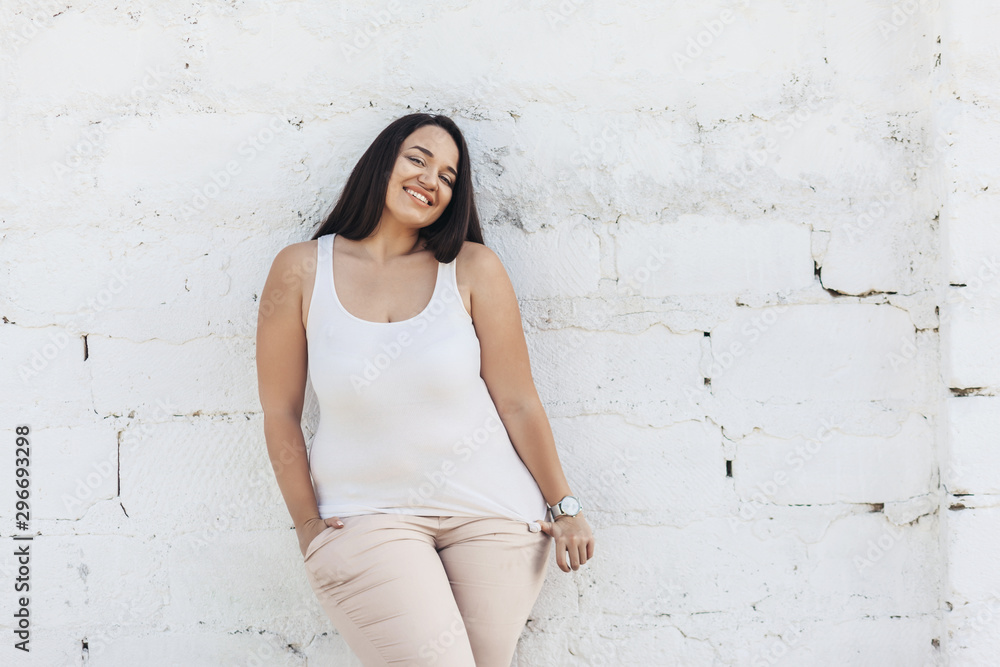 Plus size model dressed in white shirt posing over brick wall Stock ...