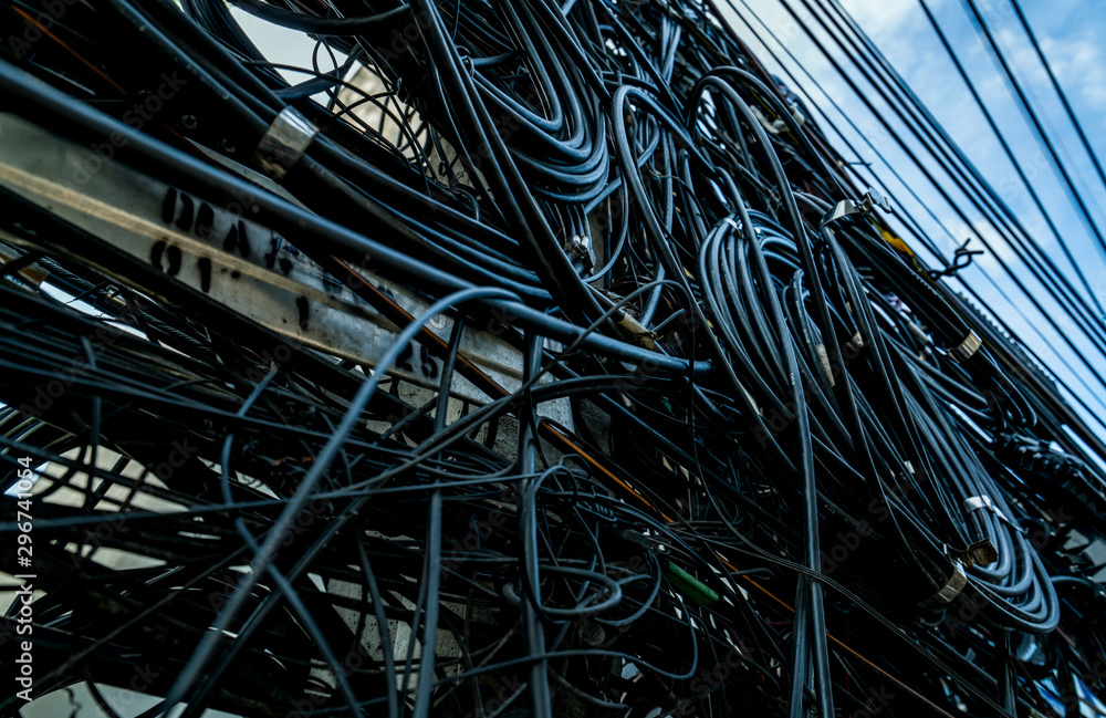 Tangled electrical wires on urban electric pole. Disorganized and messy ...