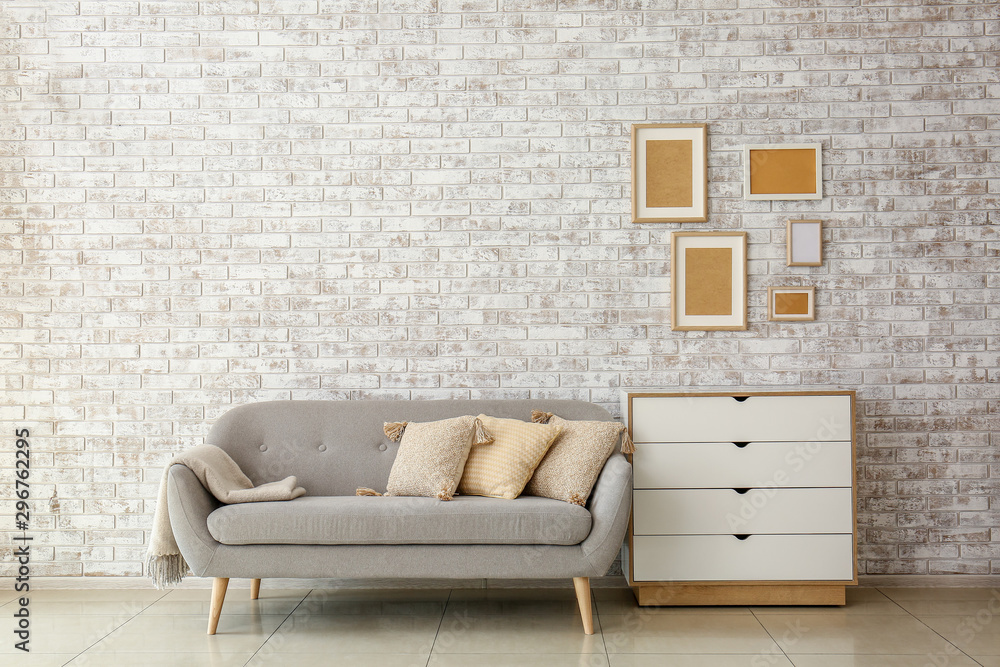 Stylish sofa with chest of drawers and pillows in room Stock Photo ...