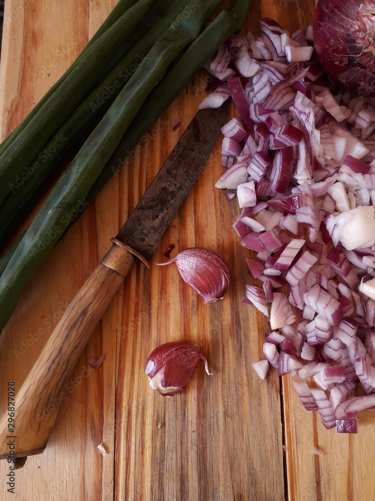 Cebolla roja picada con ajo morado y cebolla de verdeo en una tabla ...