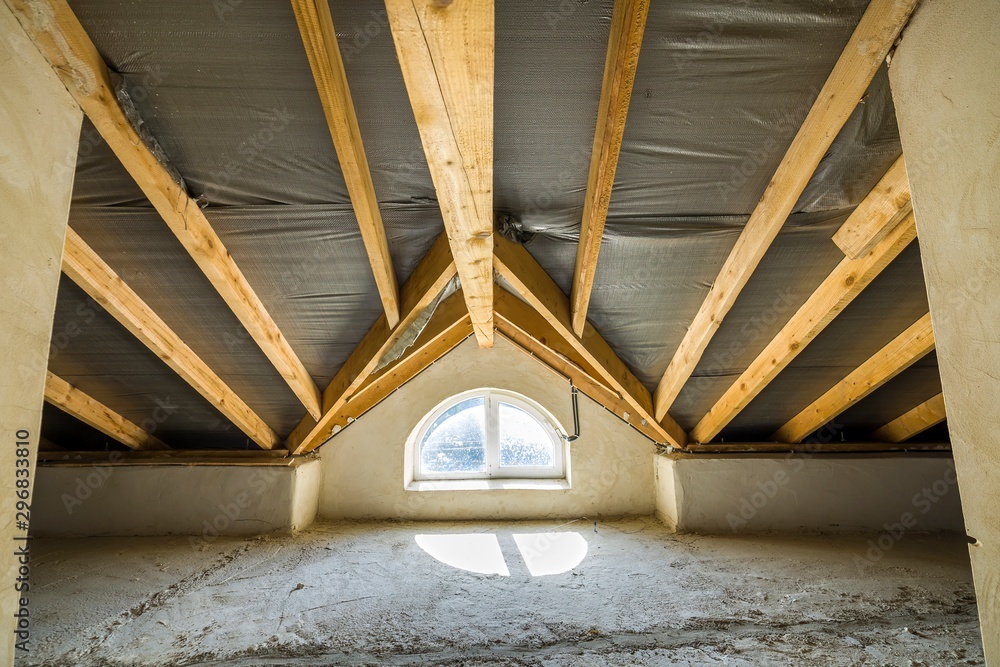 Attic of a building with wooden beams of a roof structure and a small ...