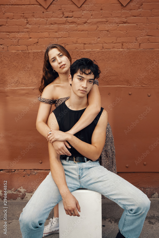 Standing woman with arms around seated man Stock Photo | Adobe Stock