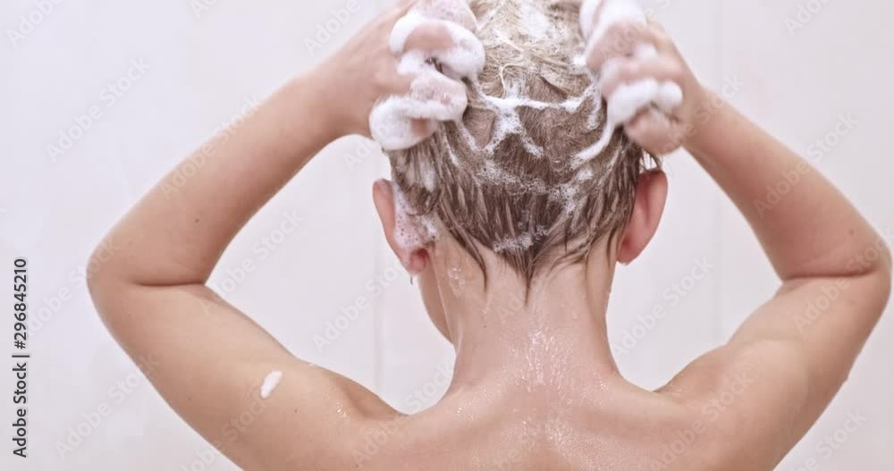 Video Stock Rear view of a little boy soaps hair with shampoo in the ...