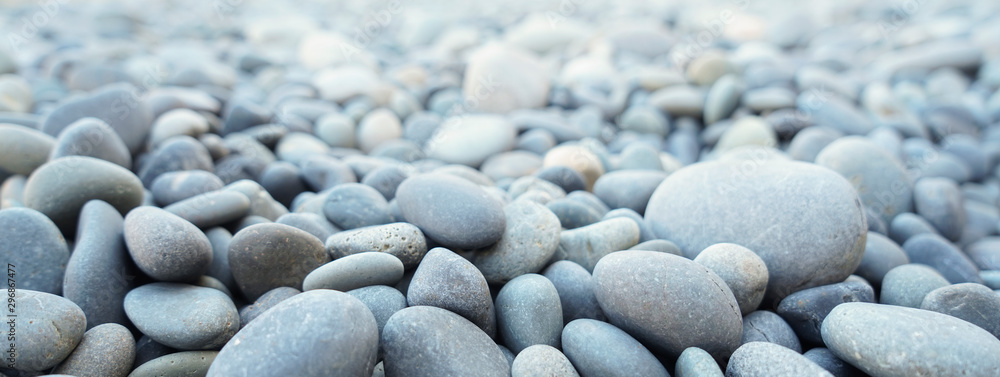 Round stones on a dry river bed outside in nature. Smooth pebbles with ...