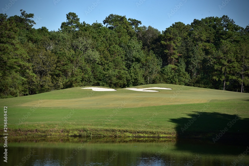 Golf course landscape, including a water hazard, sand traps and putting ...