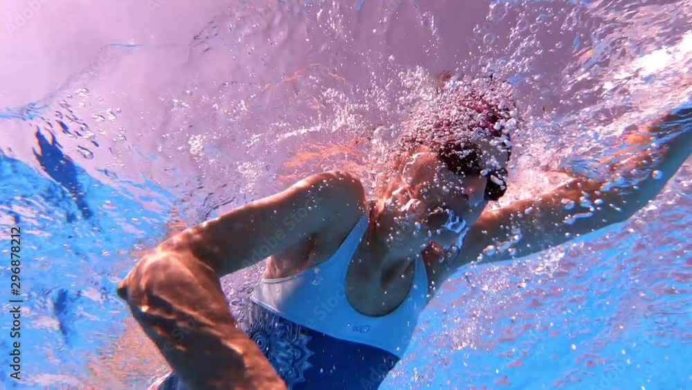 underwater bottom view of sport woman swimming crawl style in clear ...