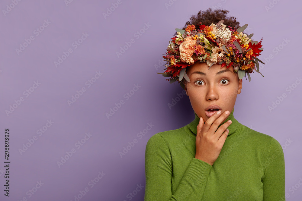 Astonished frightened ethnic woman gasps from fear, touches chin ...