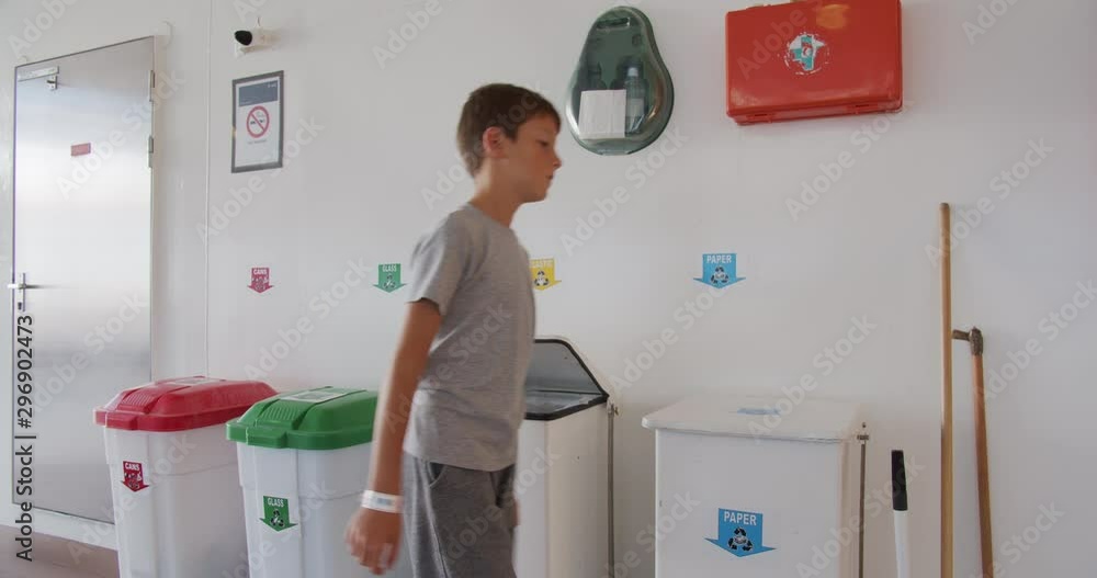 Boy throws waste in colorful, plastic garbage bins. Waste sorting and ...