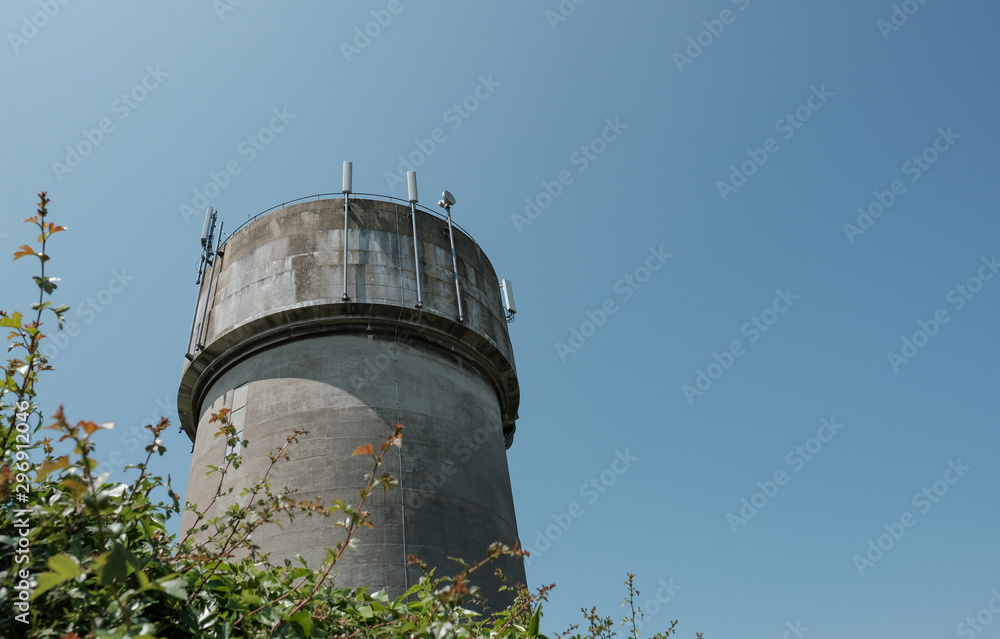 Large concrete water tower showing mobile phone communications antennas ...