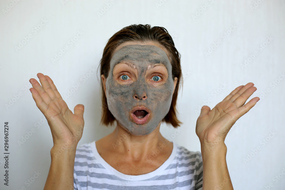 Beautiful Mature woman making face bubble charcoal mask. Surprised face ...