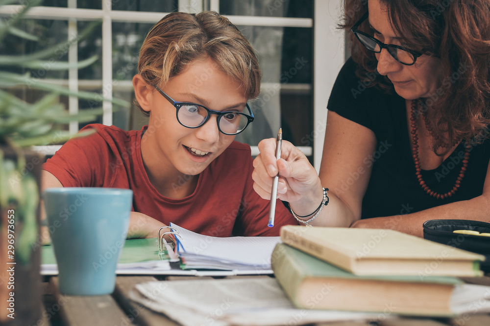 Astonished student doing homework at home with school books newspaper ...