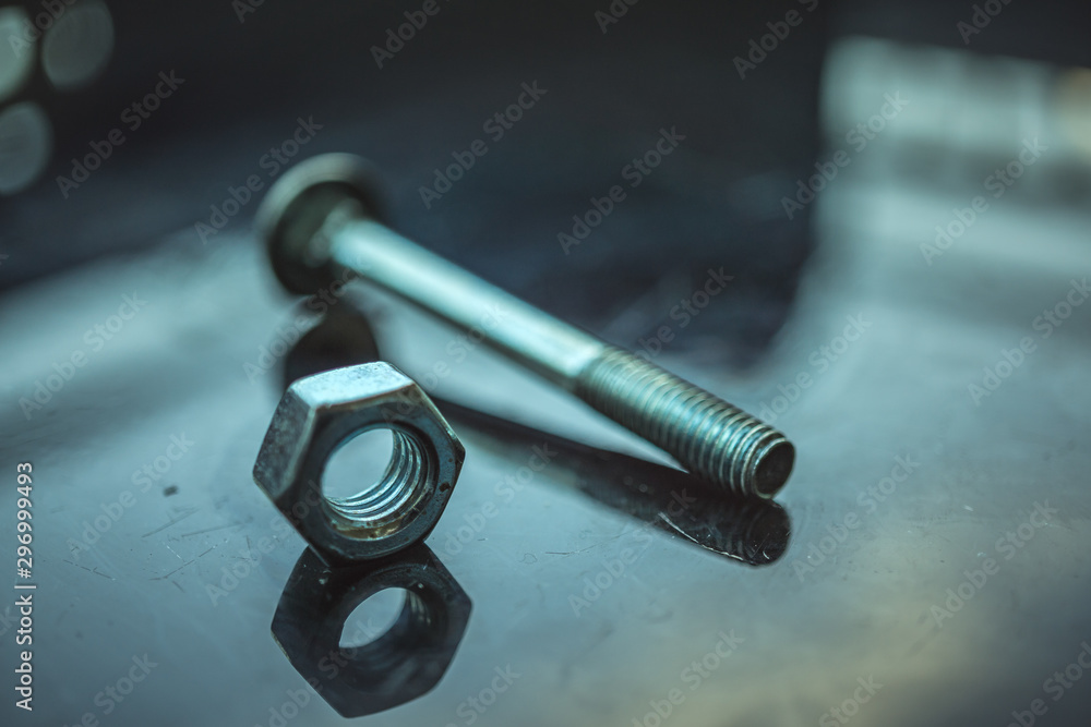 Hex nut and mating bolt on glass surface. Stock Photo | Adobe Stock