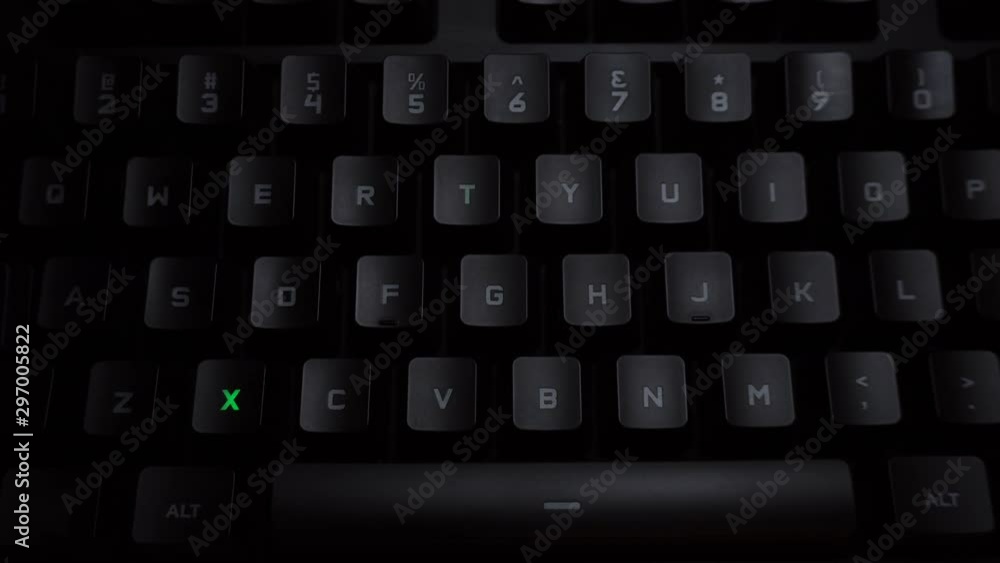 The word next is typed on a luminous computer keyboard. Black backlit ...