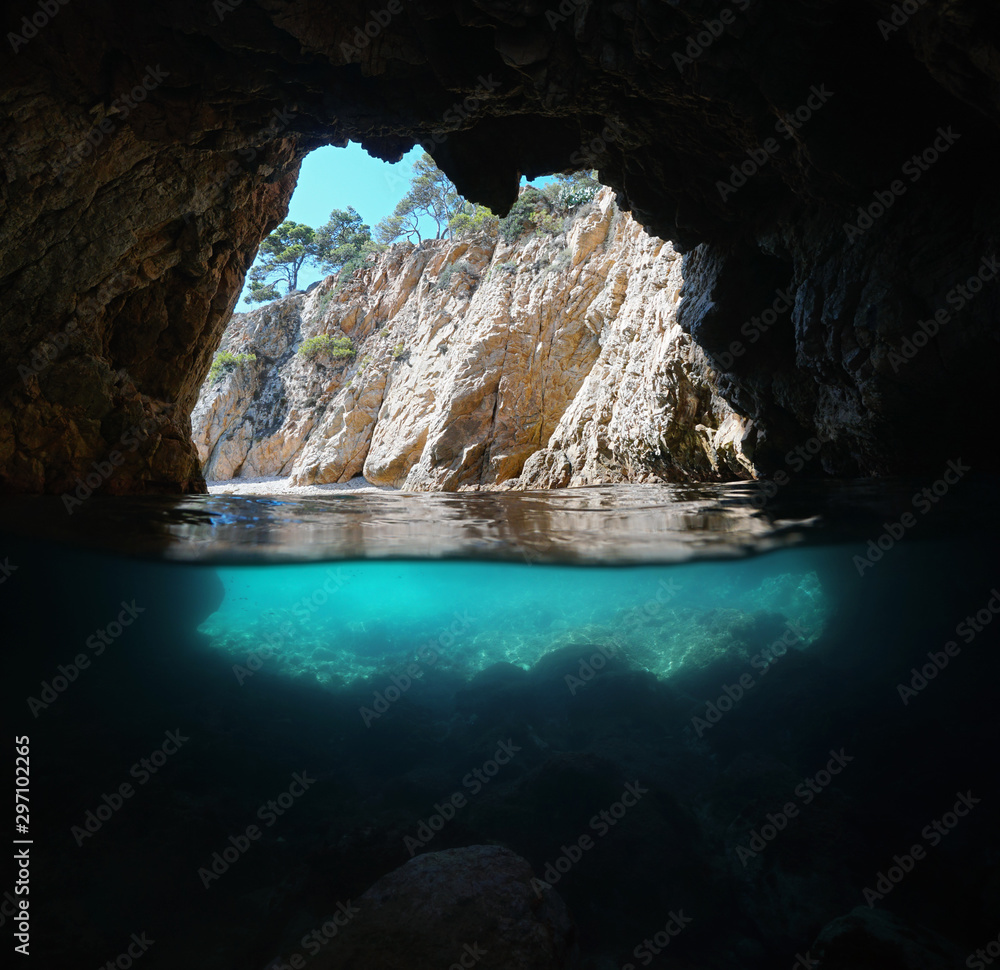 Sea cave on rocky shore, split view over and underwater, Mediterranean ...