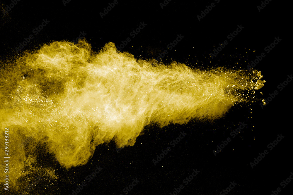 Abstract yellow powder explosion on black background.Freeze motion of ...