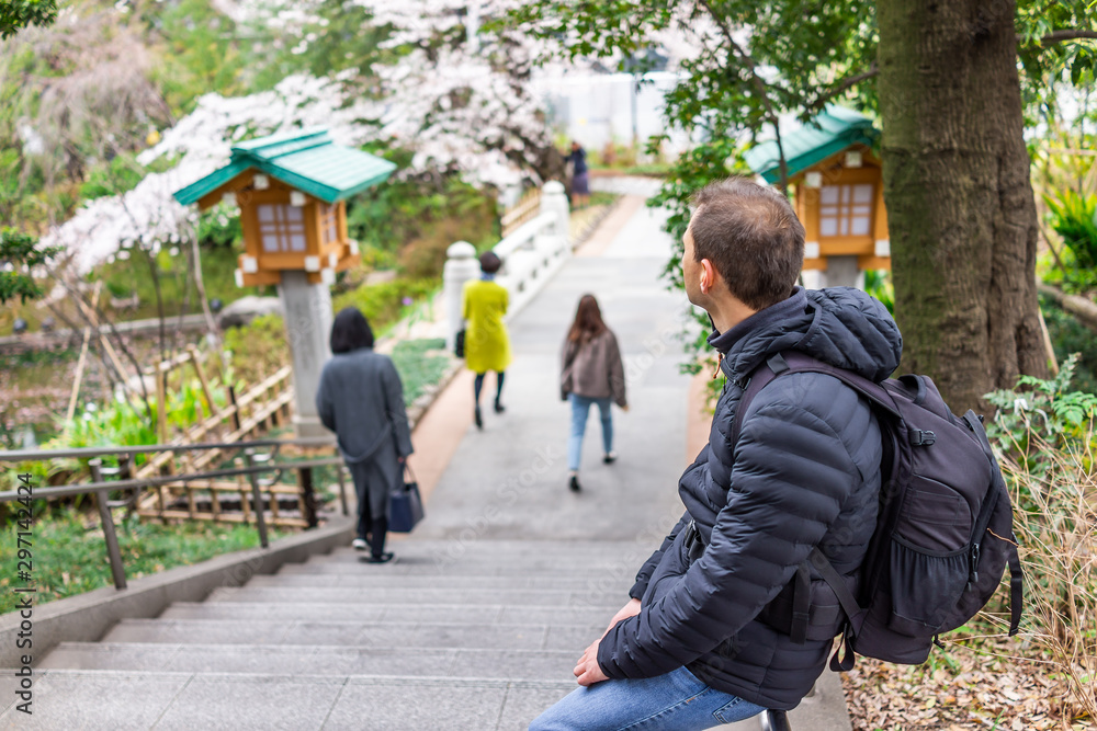 Tokyo, Japan Togo shrine temple garden with one tourist man sitting on ...
