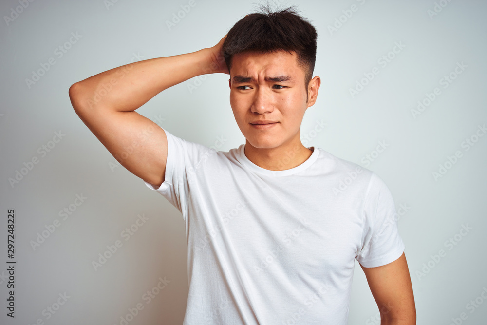 Young asian chinese man wearing t-shirt standing over isolated white ...