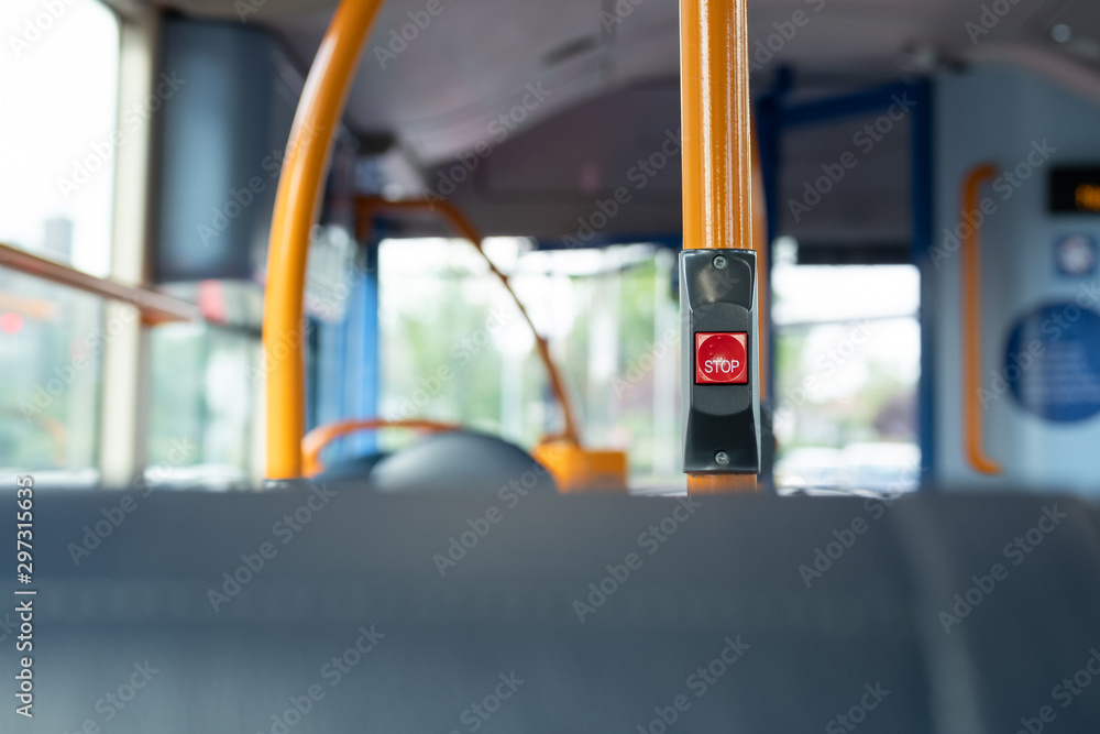Shallow focus of a red stop button on a yellow hand rail, used to ...