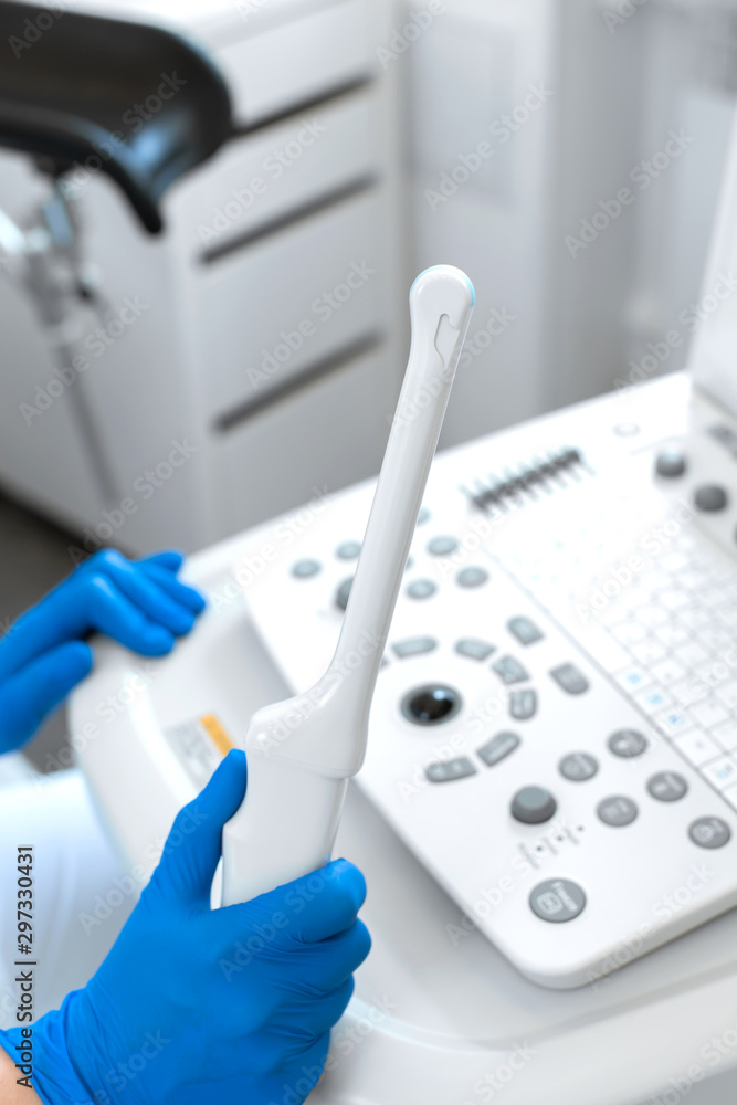 A gynecologist sets up an ultrasound machine. A transvaginal ultrasound ...