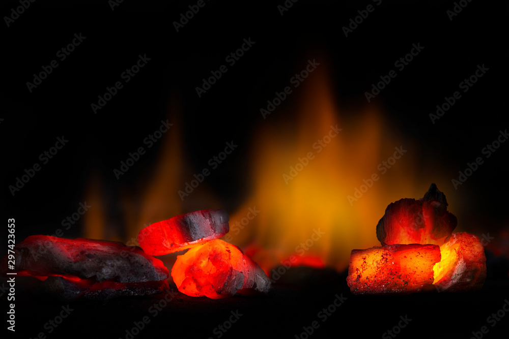 Stockfoto Red hot coal bars in focus on dark background with flames ...