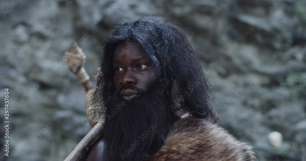 Portrait black angry neanderthals wearing animal skin holding weapon ...