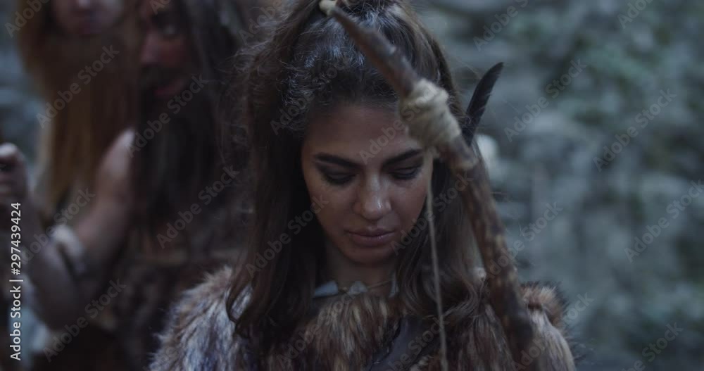 Close up woman caveman neanderthals holding weapon wearing animal skin ...