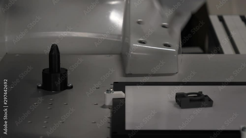 Two robot arms disconnecting production detail parts, then one part is ...