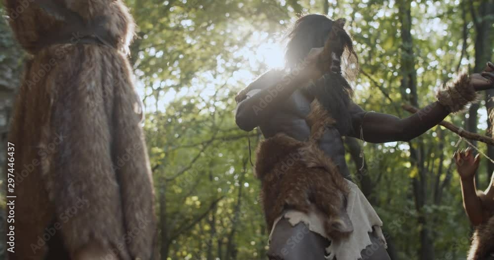 At sunlight tribe of cavemen neanderthals wearing animal skin holding ...