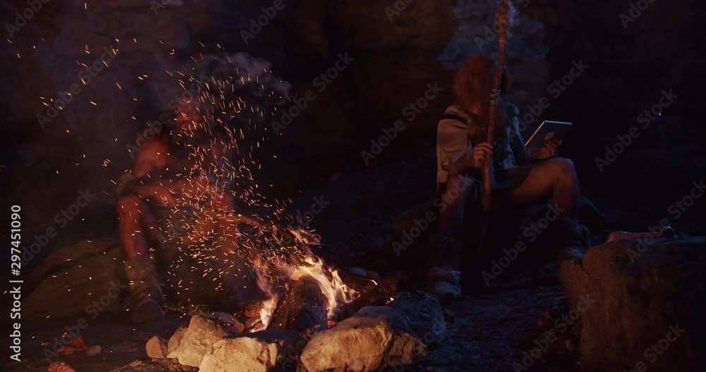 Slow motion tribe cavemen neanderthals wearing animal skin use tablet ...