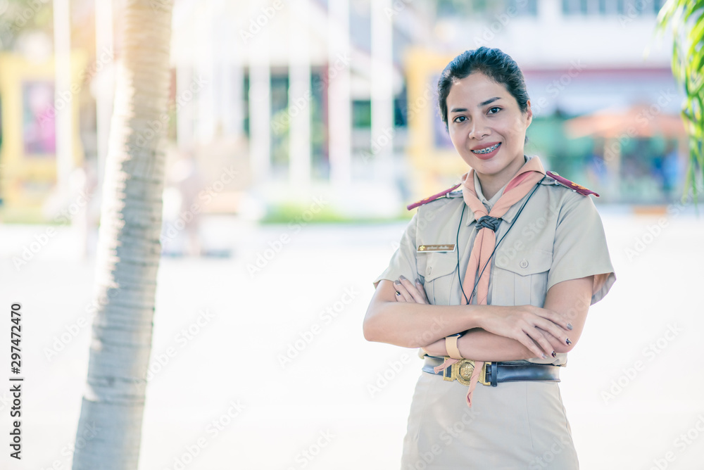 A beautiful smiling Asian female high school teacher in Thai scout ...