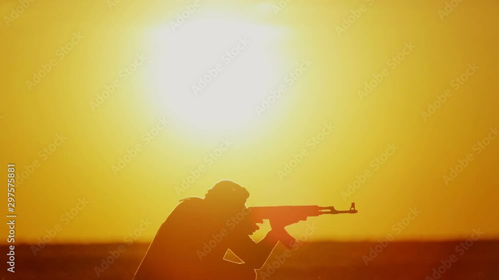 Islamic warrior with Kalashnikov at sunset day. Muslim fighter is ...