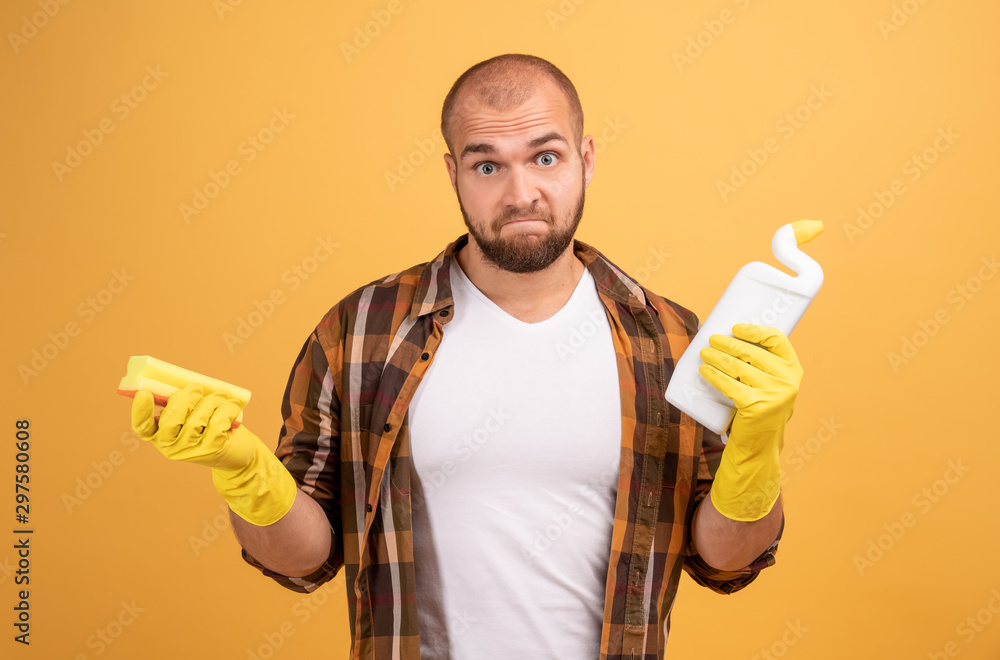 Housekeeping and cleaning concept. Unhappy confused young male janitor ...