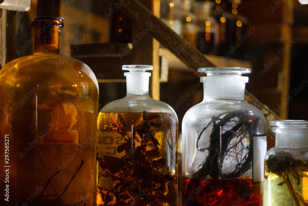 Set of alchemy bottles in laboratory of alchemist. Herb in old pots ...
