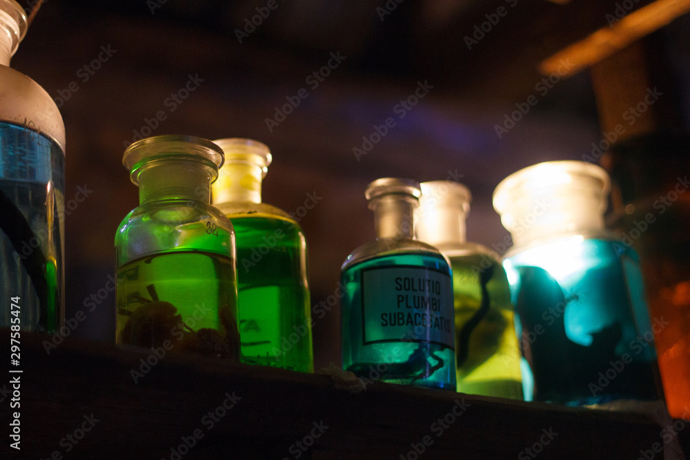 Set of alchemy bottles in laboratory of alchemist. Herb in old pots ...