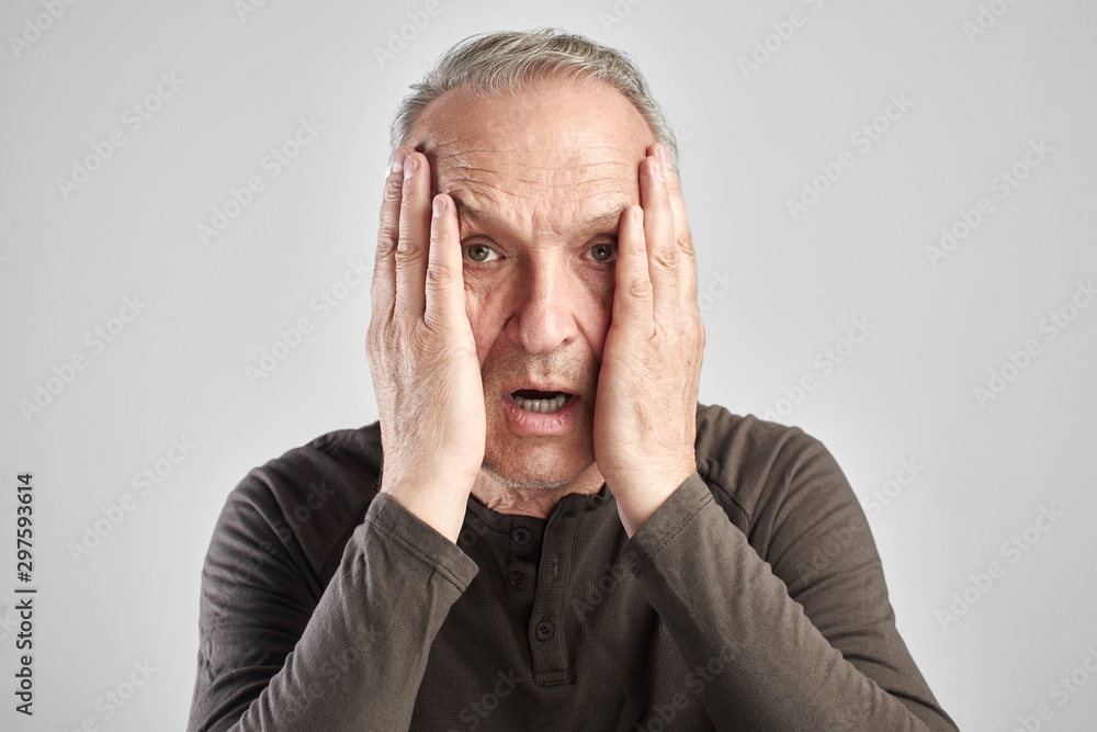 Shocked surprised senior citizen fearfully closes face with hand ...