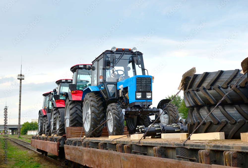 Farm tractors loaded on a freight train. Import/export of the ...