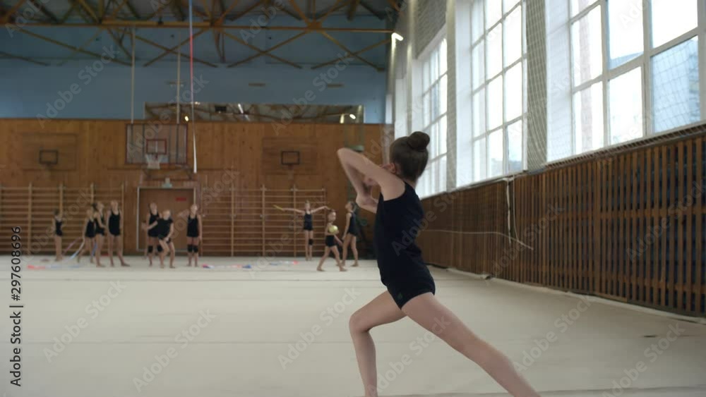 Side view of young teenage or primary school girl doing standing split ...