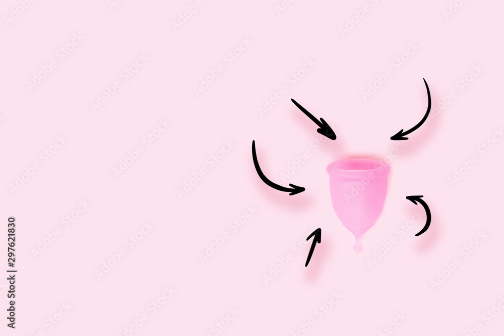 Top view of a pink menstrual cup on a color background. Products of ...