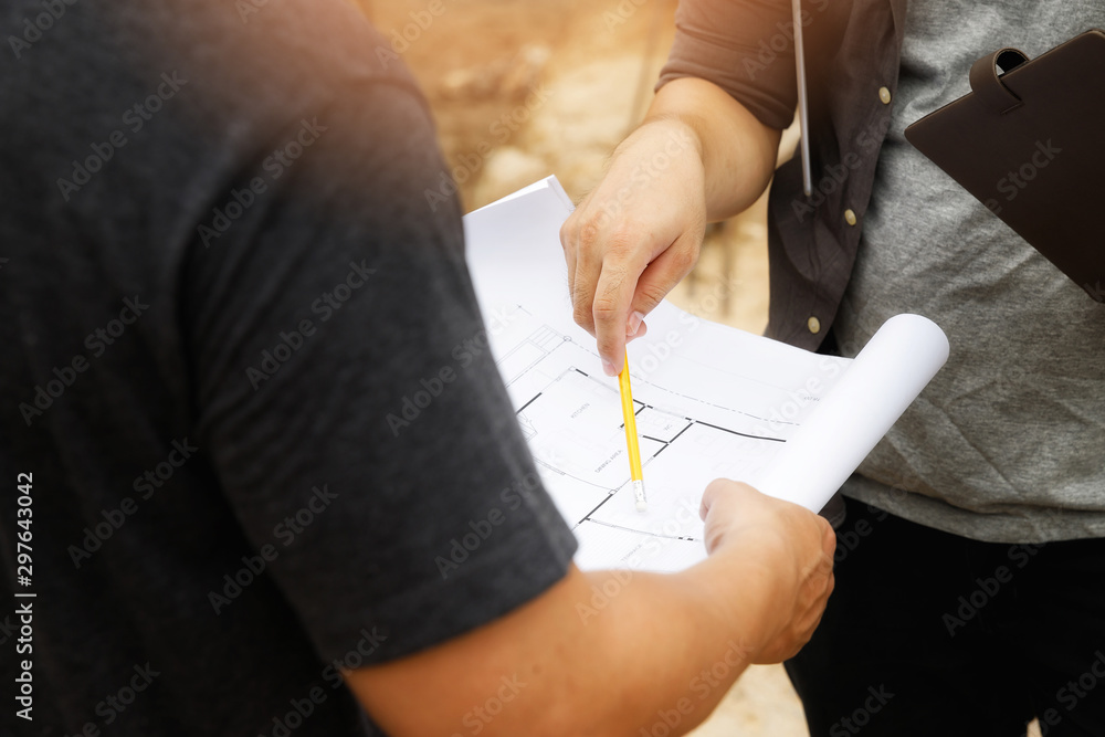 Team of construction workers discussing project details with blueprint ...