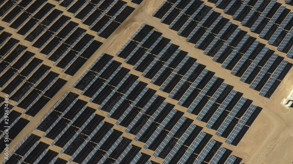 Aerial overhead view footage hundreds solar energy modules or panels rows along the dry arid ...