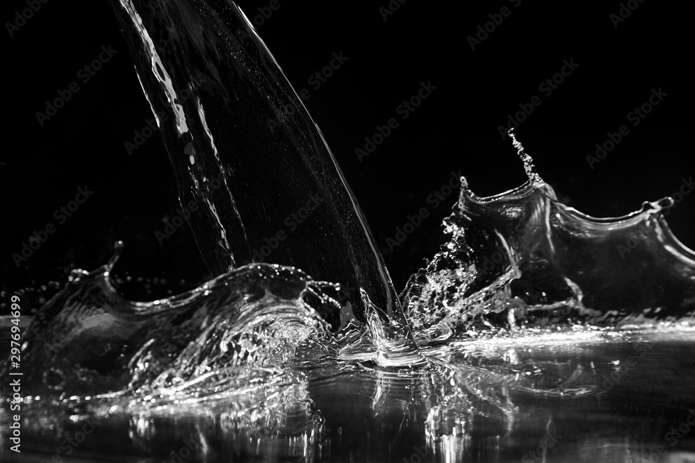 Water splash on black background. Jet and drops of clear liquid ...