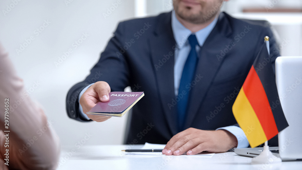 German consular officer giving passport to woman, refugee visa, asylum ...