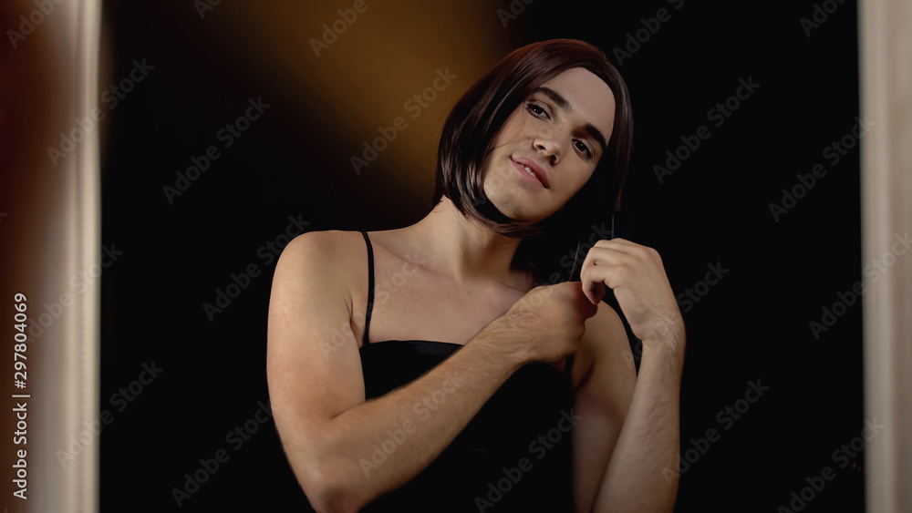 Male transgender model combing wig, happy and proud to realize ...