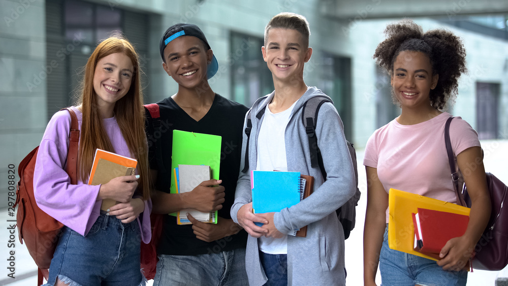 Multiracial high school students with books smiling camera, educational ...
