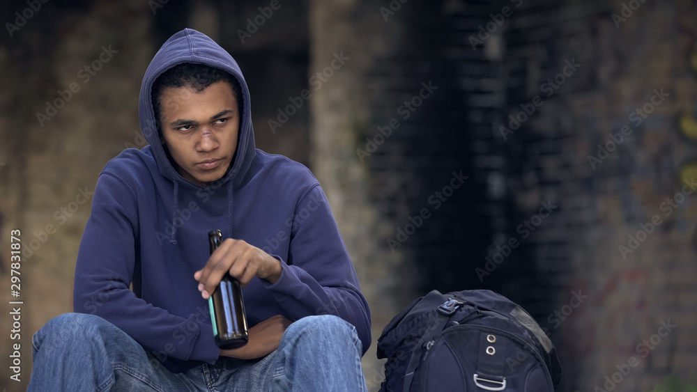 Difficult teenager with beer bottle sitting in abandoned house and ...