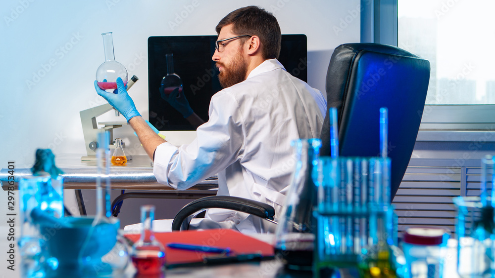 Forensic Laboratory. Lab technician examines a sample. Man with a flask ...