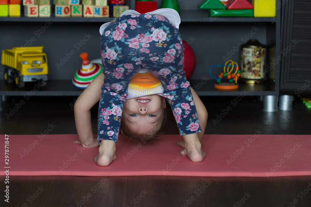 Little girl bending down making physical training indoor Stock Photo ...