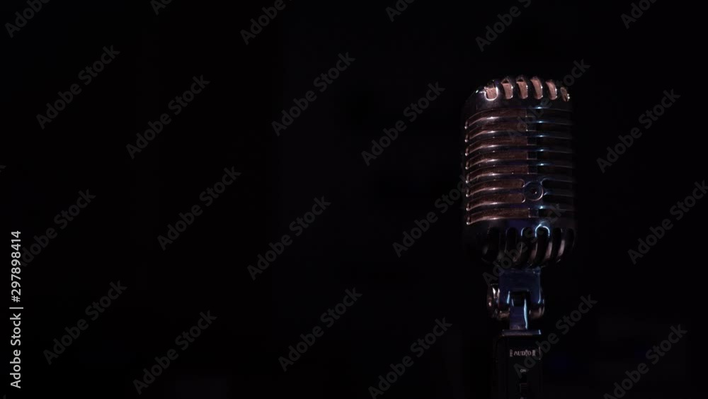 Red and white spotlights light on a chrome retro mic on the right on ...
